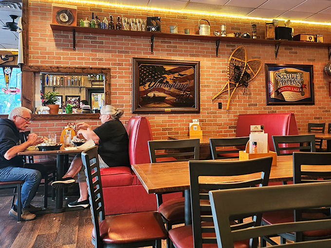 Red booth seating against exposed brick walls&mdash;the classic American pub experience where comfort meets craftsmanship in both food and atmosphere.