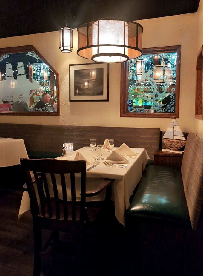 Intimate booth seating where maritime romance blooms under soft lighting and whispered seafood sweet nothings.