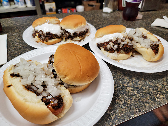 Burger assembly line of happiness. Each plate represents someone's imminent moment of pure food joy. The anticipation is palpable.