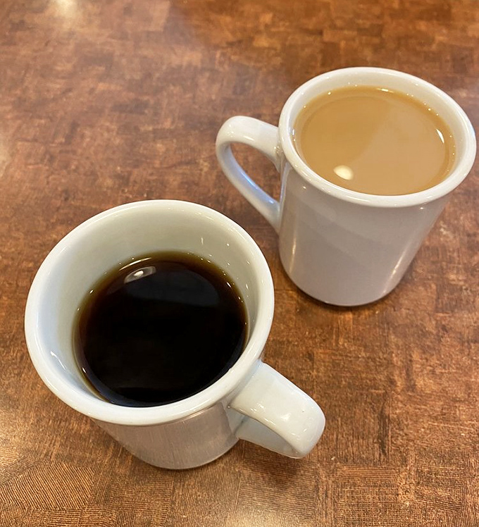 Coffee served two ways: black as midnight or lightened with cream &ndash; either way, it's the lifeblood that powers Nick's morning regulars.