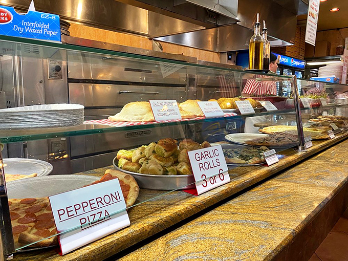 The display counter&mdash;where pizza dreams are born and diet resolutions go to die. Each sign promises a different path to delicious satisfaction. 