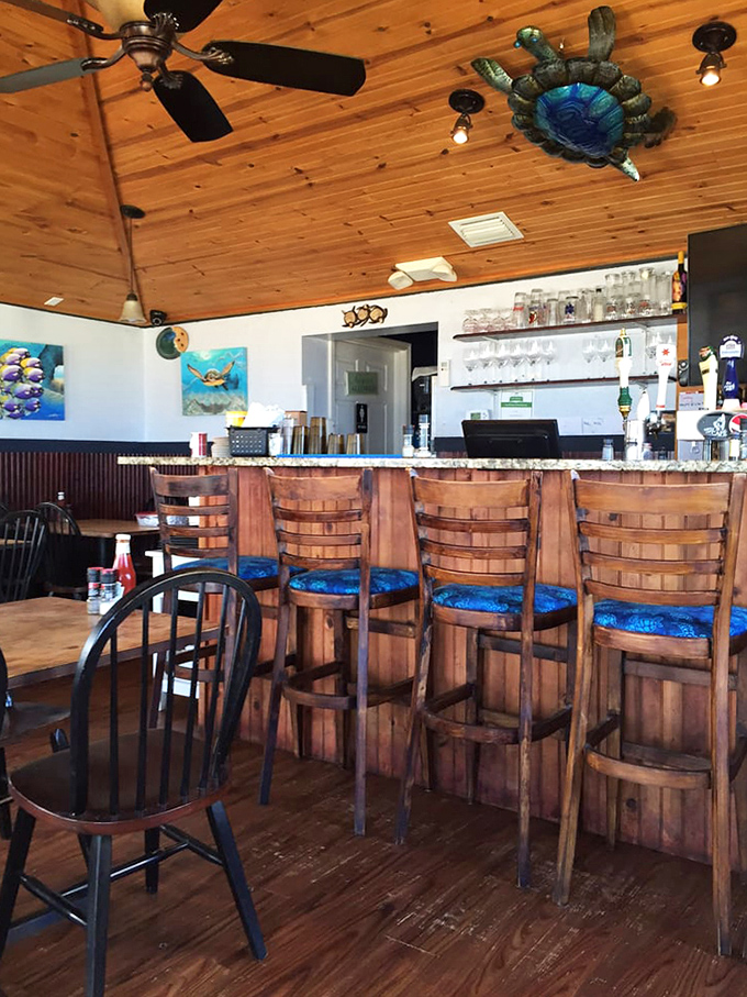 The bar area, with its blue-cushioned stools and weathered wood, feels like the coastal hangout you've been searching for your entire vacation-planning life.