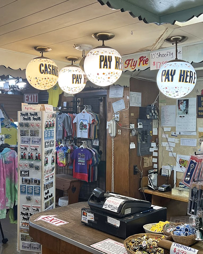 Old-fashioned cash register surrounded by globe lights spelling "PAY HERE" &ndash; retail nostalgia that actually works perfectly.