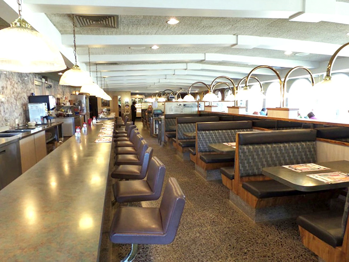 The counter where regulars have claimed their spots for decades, swiveling on vinyl stools while solving the world's problems over coffee refills.