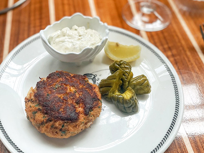 A perfectly seared crab cake flanked by pickled peppers&mdash;proof that simplicity, when executed flawlessly, is the ultimate luxury.