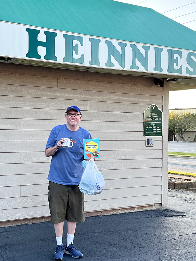 The image shows a visitor clearly delighted with their Heinnies haul &ndash; that smile says everything about what awaits inside.