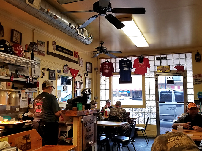 T-shirts hang like battle flags, ceiling fans spin lazily overhead, and every surface tells a story. This isn't decoration&mdash;it's a living museum of local pride.