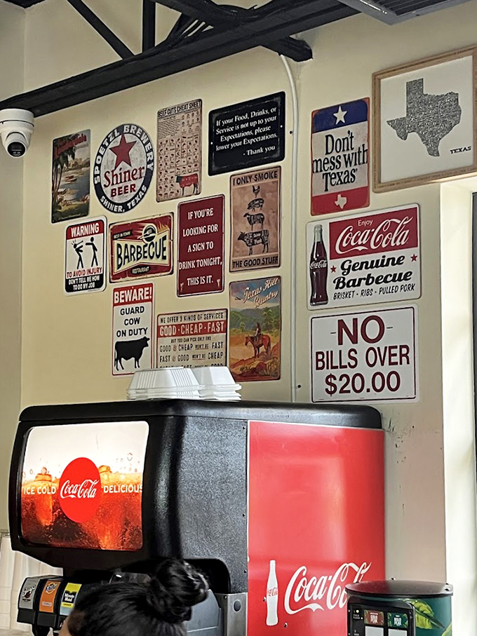 Wall decor that tells you everything about priorities here: Texas inspiration, barbecue dedication, and absolutely no bills over $20.