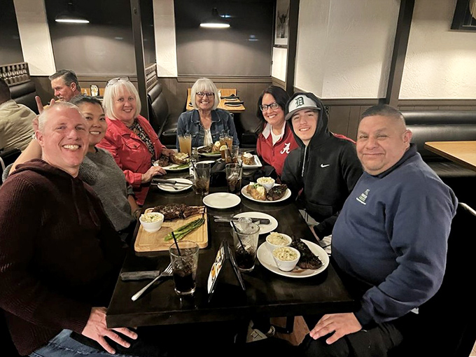 Happy diners sharing stories and steaks&mdash;the universal language of good food bringing people together around a table of plenty.