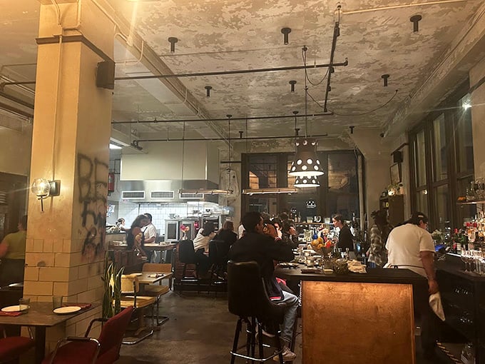 The dining room buzzes with conversation and clinking glasses&mdash;industrial-chic meets warm hospitality under weathered ceilings that tell stories of the building's past.