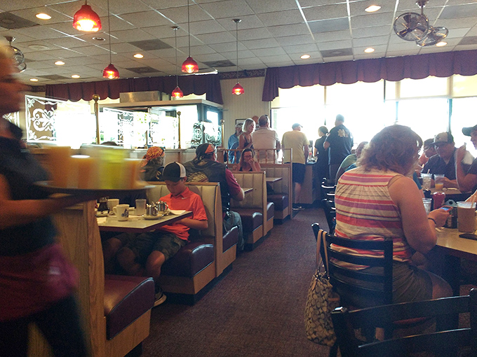 A dining room where strangers become temporary neighbors, united by the universal language of "pass the syrup, please."