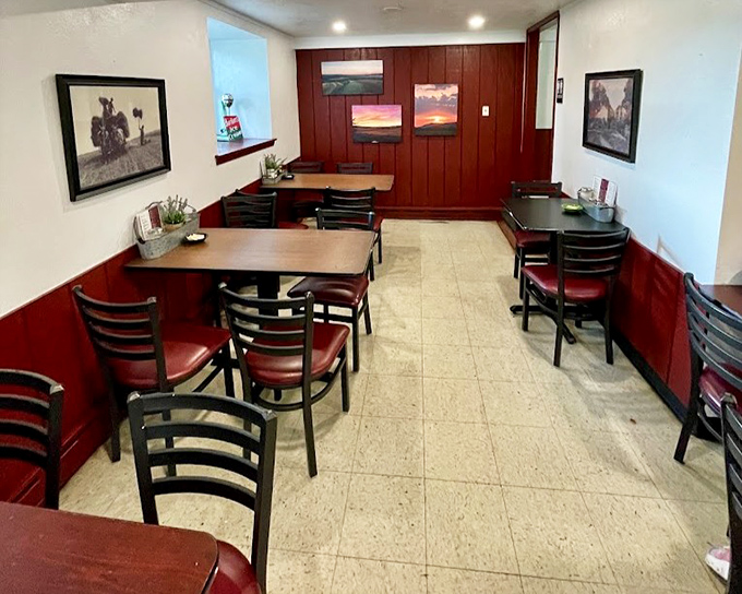 Red wainscoting and landscape photographs create a dining room that feels like Sunday dinner at a favorite relative's.