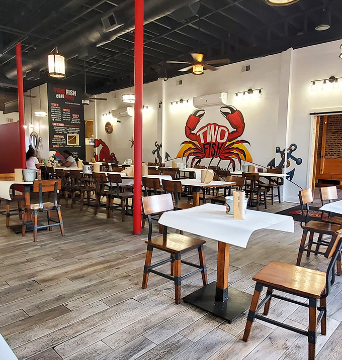 Red support columns stand like sentinels in a sea of wooden tables, while the crab mural reminds you who's boss in this establishment.