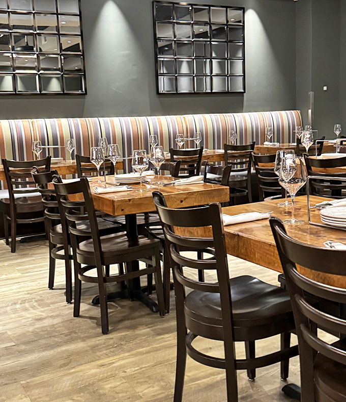 Banquette seating with striped upholstery offers the perfect perch for people-watching while debating between tiramisu or cannoli.