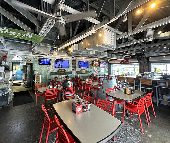Red chairs pop against industrial-cool surroundings, creating a casual vibe where nobody minds if you lick your fingers clean.