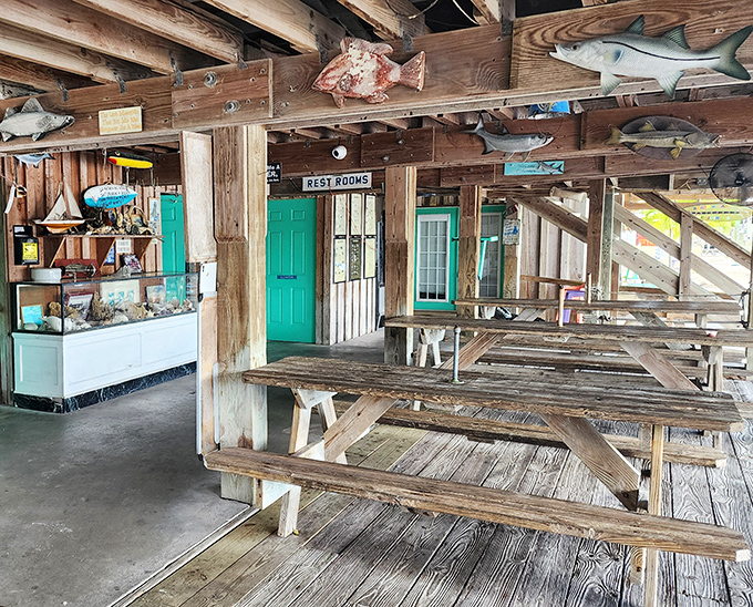 Wooden picnic tables under mounted fish&mdash;the interior design philosophy here is simple: "If it ain't broke, don't fix it."
