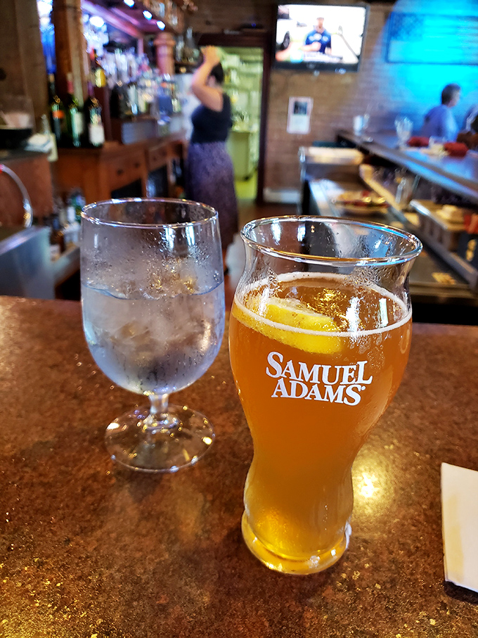 A perfectly poured Samuel Adams alongside water that's actually served in proper glassware&mdash;because Harper's knows presentation matters even with the basics.