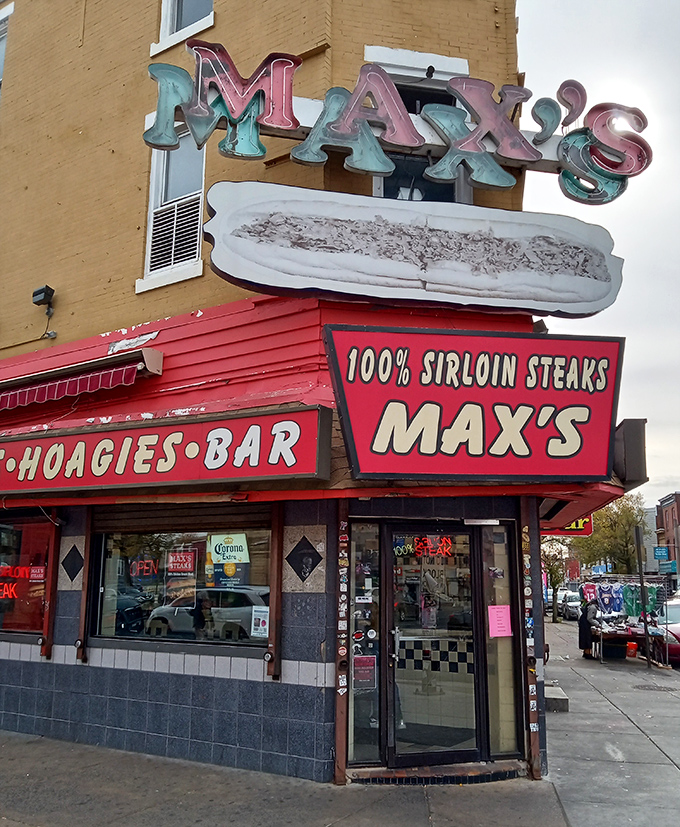 The vintage neon sign glows like a beacon for hungry travelers. That illuminated cheesesteak might be the most honest advertising in America.