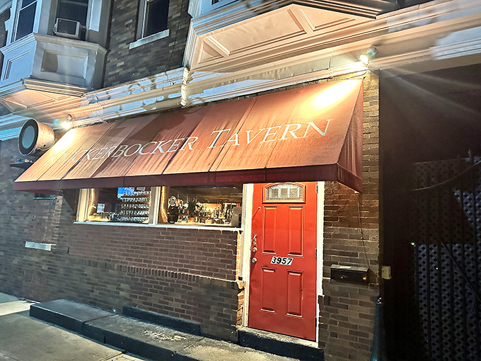The red door glows like a beacon in the night, promising refuge, good food, and the kind of welcome that makes strangers into regulars.