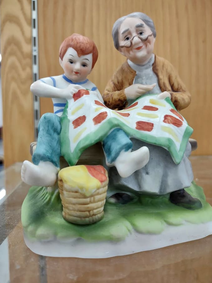 Porcelain storytellers on display. This charming figurine of grandma and child quilting together captures the nostalgic Americana that thrift stores preserve so beautifully.