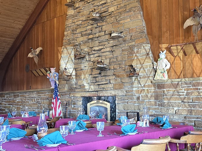 The stone fireplace anchors the room like a culinary North Star. Those turquoise napkins add just the right pop of color against the classic burgundy tablecloths.