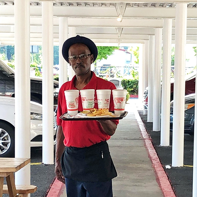 A dedicated server carries the tradition of hospitality on a tray&mdash;four drinks and golden fries balanced with the skill that comes from years of practice.