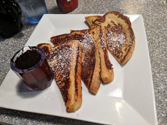 French toast dusted with powdered sugar and served with syrup&mdash;breakfast's answer to "How can we make bread even more irresistible?"