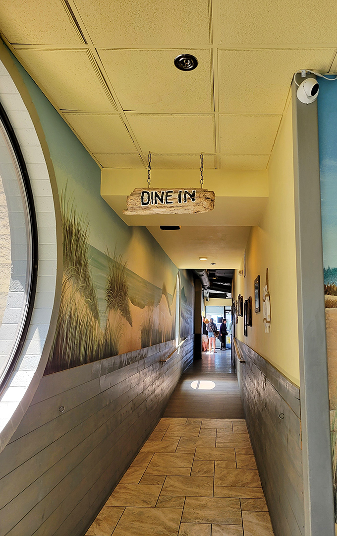 The "Dine In" sign hanging like driftwood art guides hungry visitors through a hallway that feels like entering a seaside secret.