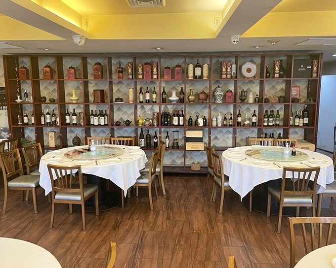 The dining room's elegant display shelves showcase bottles like trophies, a testament to meals worth celebrating.