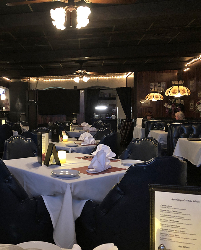 White tablecloths and navy leather chairs create dining sanctuaries where memories are made between bites of perfectly cooked steak.