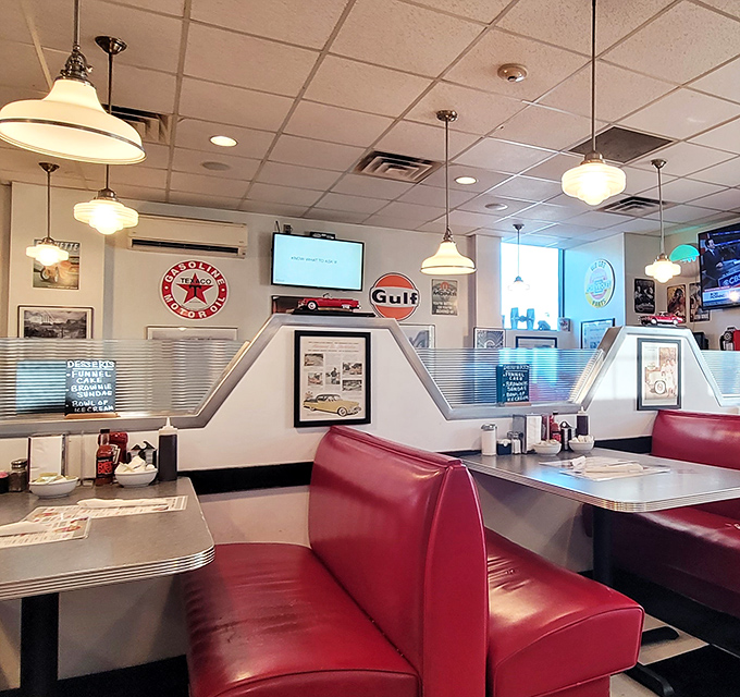 Red booths against metallic accents create that quintessential diner atmosphere where conversations flow as freely as the coffee.
