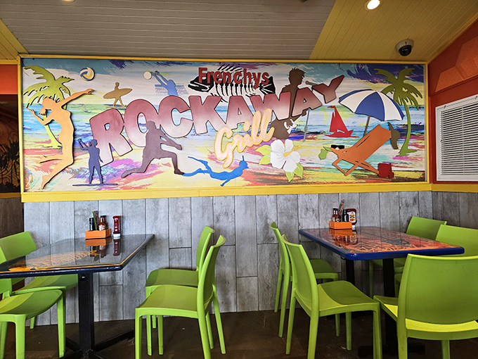 The wall mural captures the essence of beach life, providing a colorful backdrop for conversations that flow as easily as the cocktails.