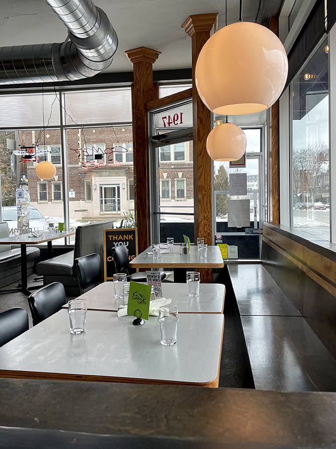 Spherical pendant lights cast a warm glow over tables where memories are made. The windows frame Milwaukee's East Side like living paintings.