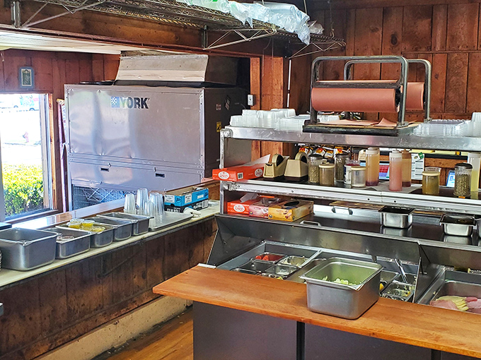 The kitchen window offers a glimpse into where the magic happens, complete with all the stainless steel a deli needs.