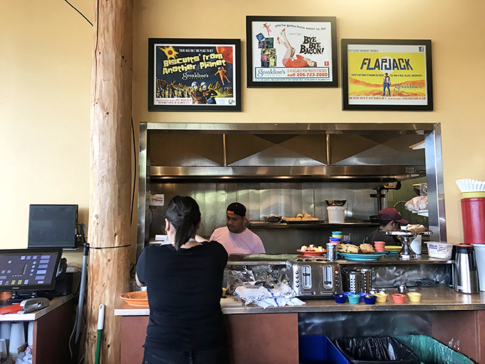Behind every great breakfast is a bustling kitchen where morning magic happens, framed by vintage-inspired posters that celebrate food culture.
