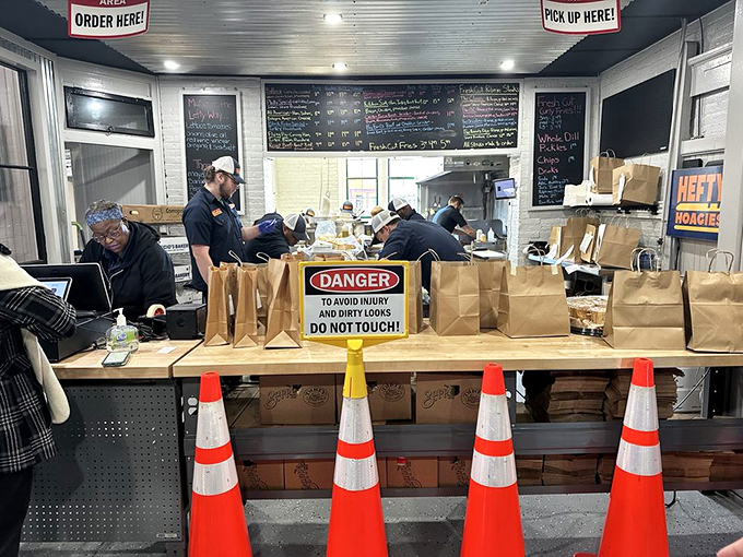Behind the scenes, the sandwich artists work their magic while danger signs warn of serious deliciousness ahead.