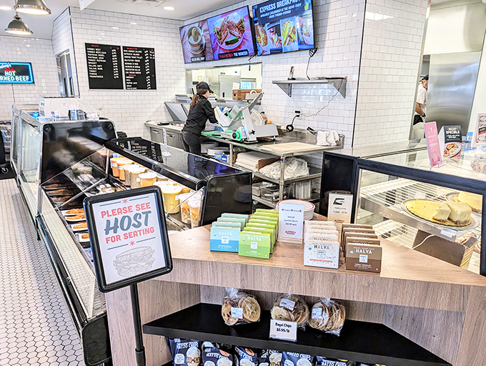 Behind the counter, the kitchen hums with efficiency while display cases tempt you with their deli treasures.