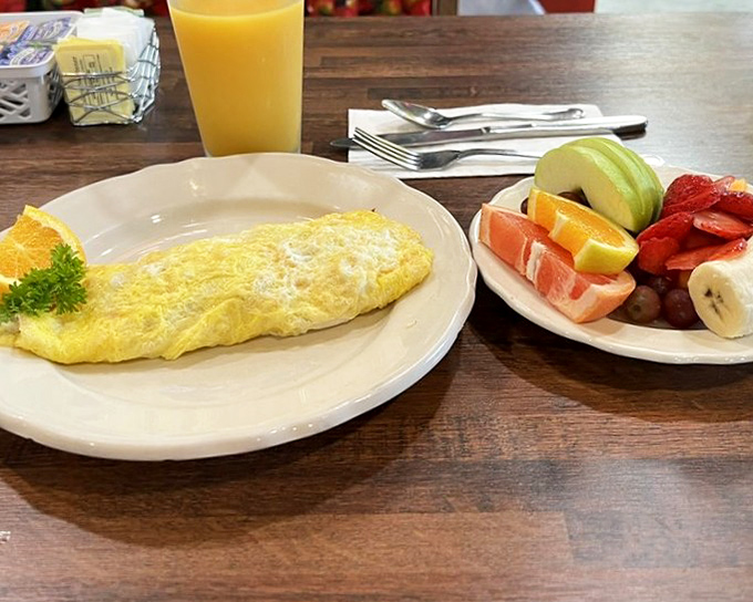 Perfect omelet paired with fresh fruit&mdash;because balance is everything, even in comfort food paradise.