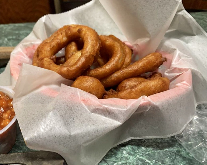 Golden, crispy onion rings nestled in paper&mdash;simple pleasures that make you wonder why anyone bothers with fancy appetizers.