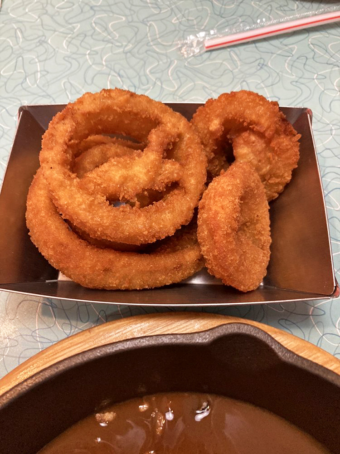 Onion rings with the perfect crunch-to-tenderness ratio, ready for their dip in that warm pool of gravy waiting patiently below.