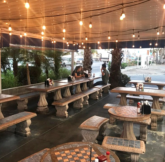 String lights transform this outdoor patio into a coastal California dream – the perfect backdrop for seafood feasting under the palms.