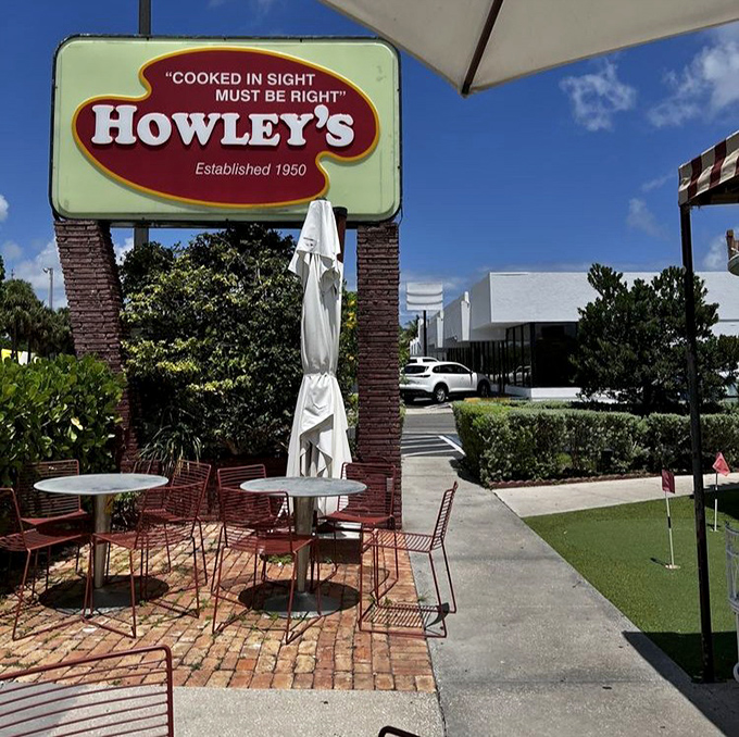 "Cooked in sight must be right" proclaims the vintage sign, while the mini-golf putting green adds a playful touch to outdoor dining.