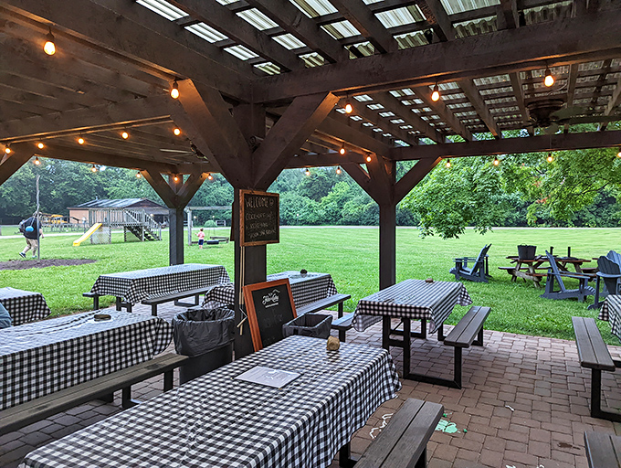 The outdoor patio combines checkered tablecloths with string lights, creating an al fresco classroom where nature provides the perfect backdrop for dinner.