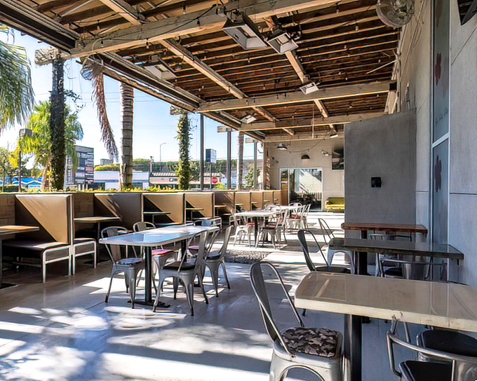 California sunshine floods the outdoor patio, where palm trees provide nature's ambiance. Al fresco dining with that perfect SoCal breeze.