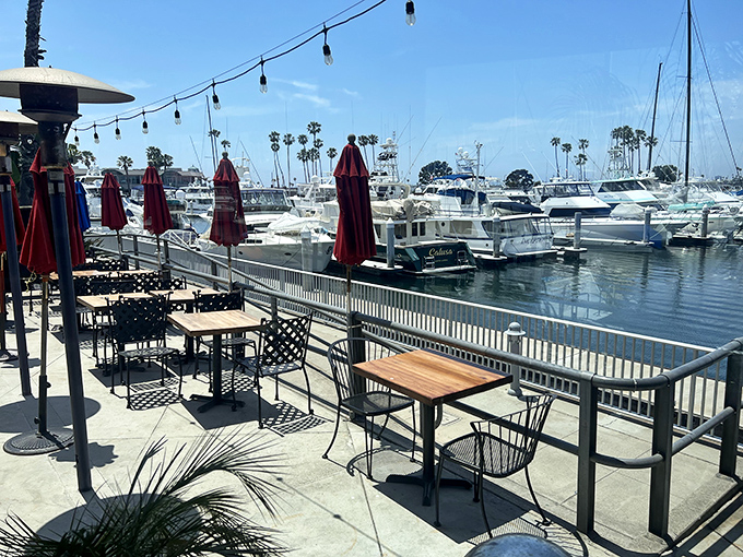 Outdoor seating with a million-dollar view! Those red umbrellas aren't just for shade&mdash;they're exclamation points on a perfect marina dining experience.