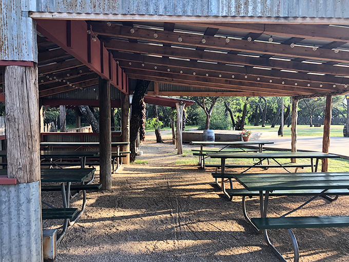 Outdoor dining under corrugated metal and Texas sky &ndash; where picnic tables become the setting for unforgettable meals.