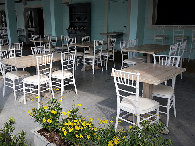 Outdoor seating that whispers "island breeze breakfast" with cheerful yellow flowers standing guard against any potential morning grumpiness.