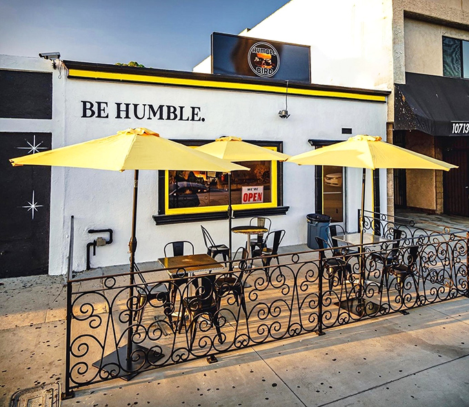 Three yellow umbrellas standing guard over the sidewalk patio &ndash; California sunshine meets Nashville heat in perfect harmony.