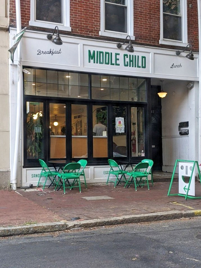 Sidewalk seating with signature green chairs invites passersby to pause for a sandwich moment on Philadelphia's brick-lined streets.