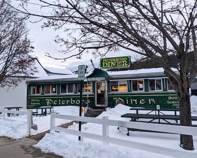 Even in winter's embrace, the Peterborough Diner stands defiant&mdash;a warm green beacon promising comfort food salvation amid New Hampshire snowdrifts.